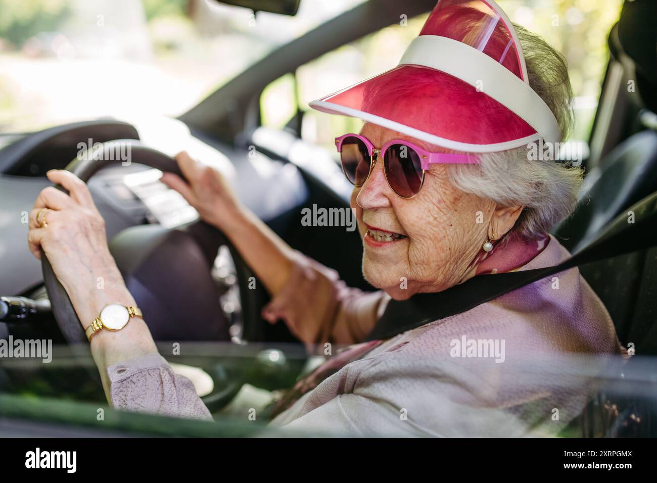 Happy senior woman driving car alone, enjoying car ride. Safe driving ...