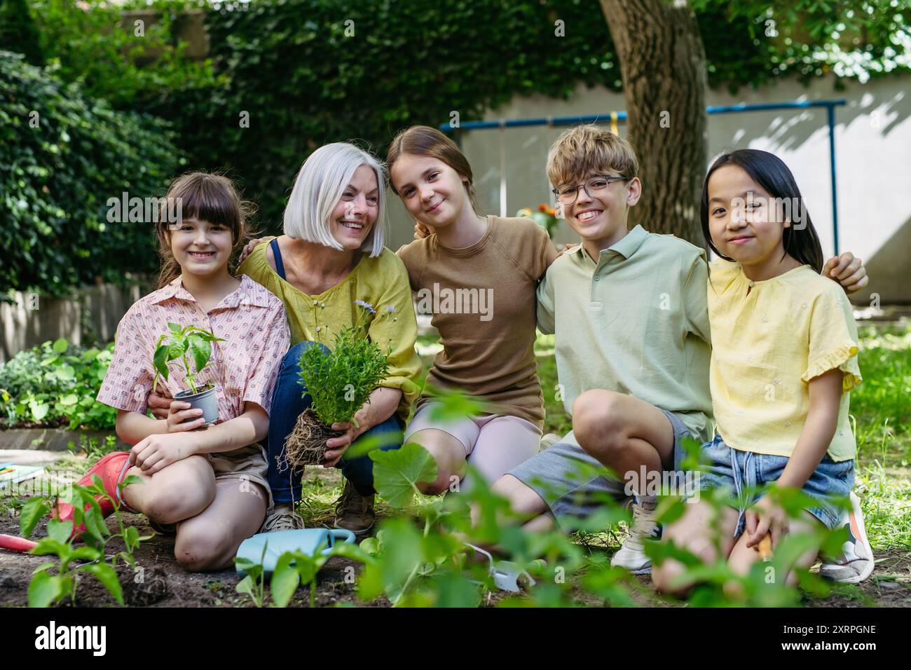 Portrait of students and female teacher at outdoor sustainable ...