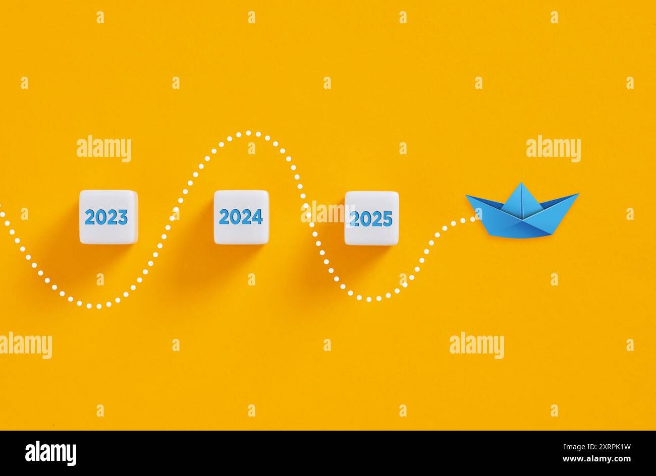 Blue paper boat sailing on dotted line through years 2023, 2024, and ...