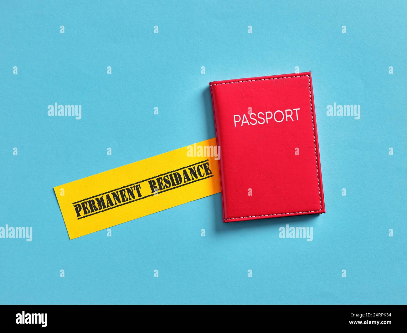 Red passport lying near permanent residence sign over blue background ...