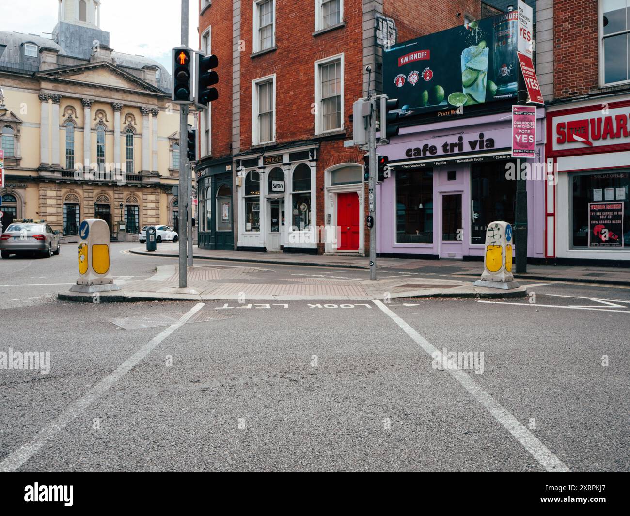 At a city center crossroads, traffic lights signal the way as vehicles ...