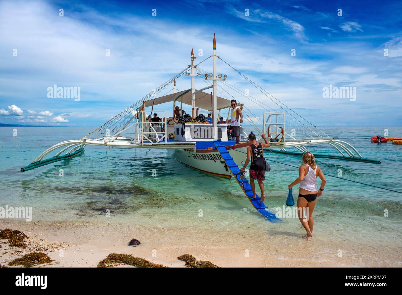 Traditional boats moored off a tiny tropical island beach in the ...