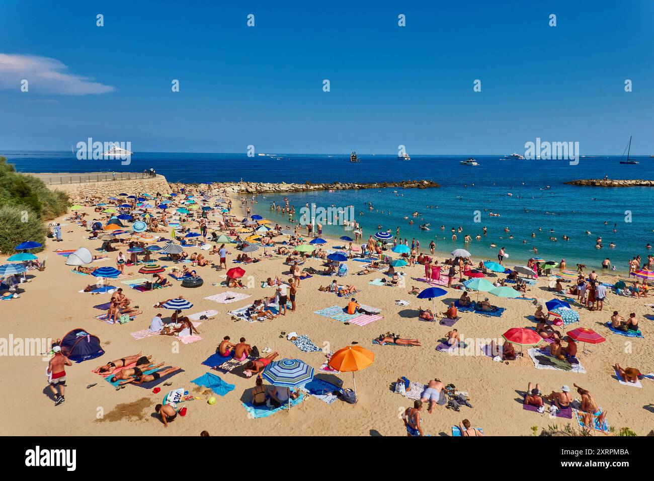 Crowded Sunny Beach Holiday Scene with Colourful Umbrellas and Clear ...