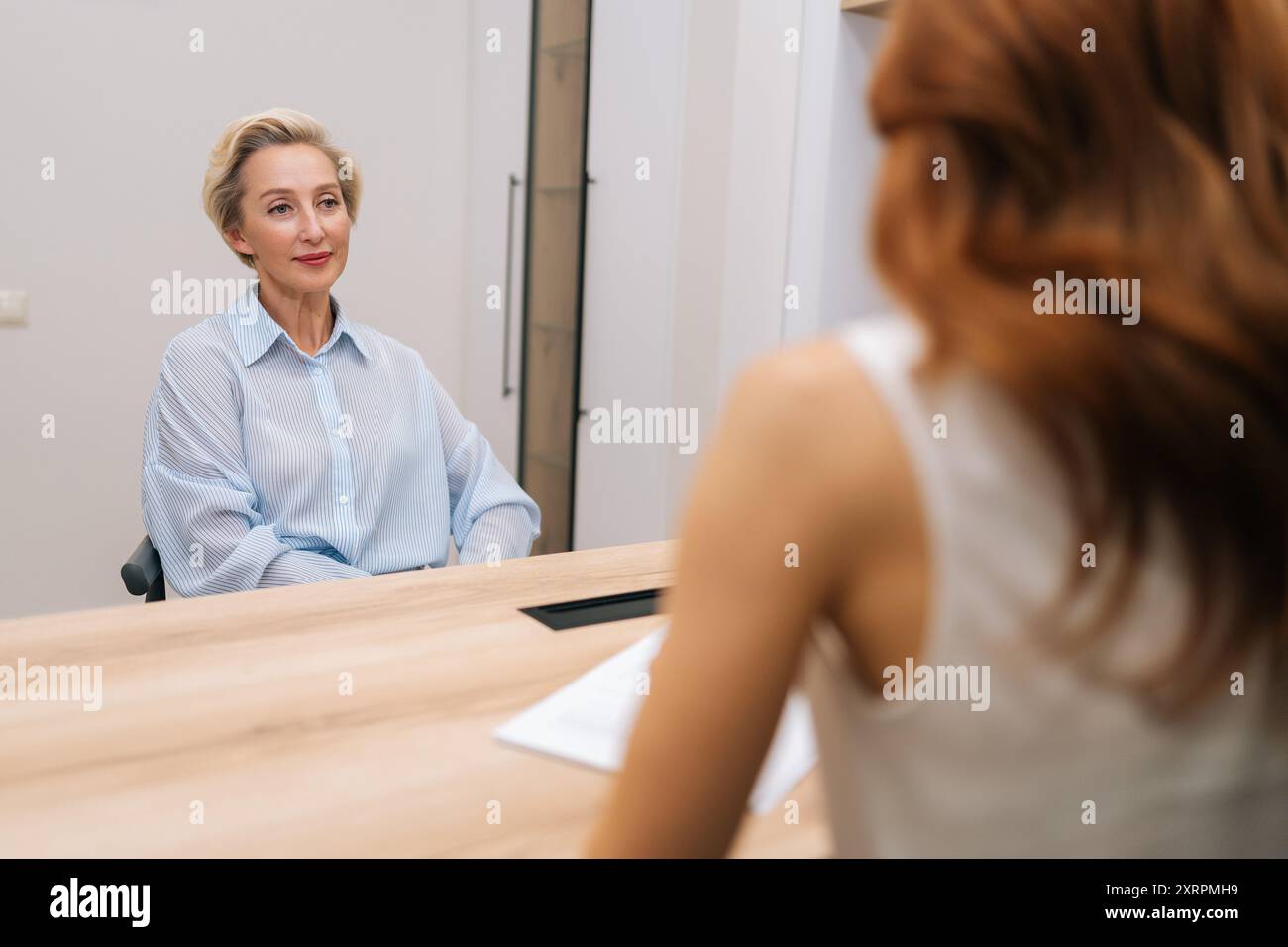 Over shoulder shot of mature adult female job applicant talk at ...