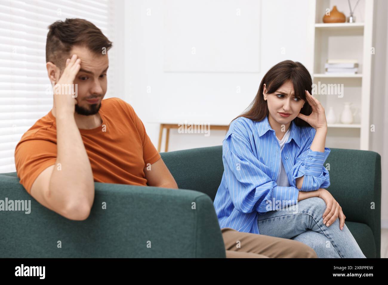Embarrassed couple ignoring each other on sofa at home Stock Photo - Alamy