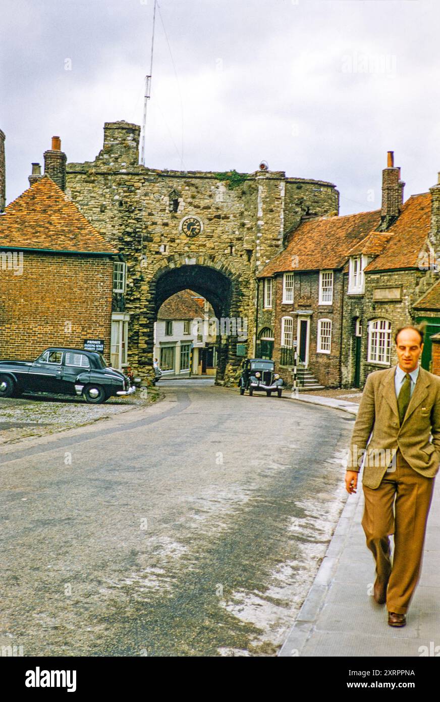 Man walking on pavement with the Landgate gatehouse, Rye, East Sussex ...