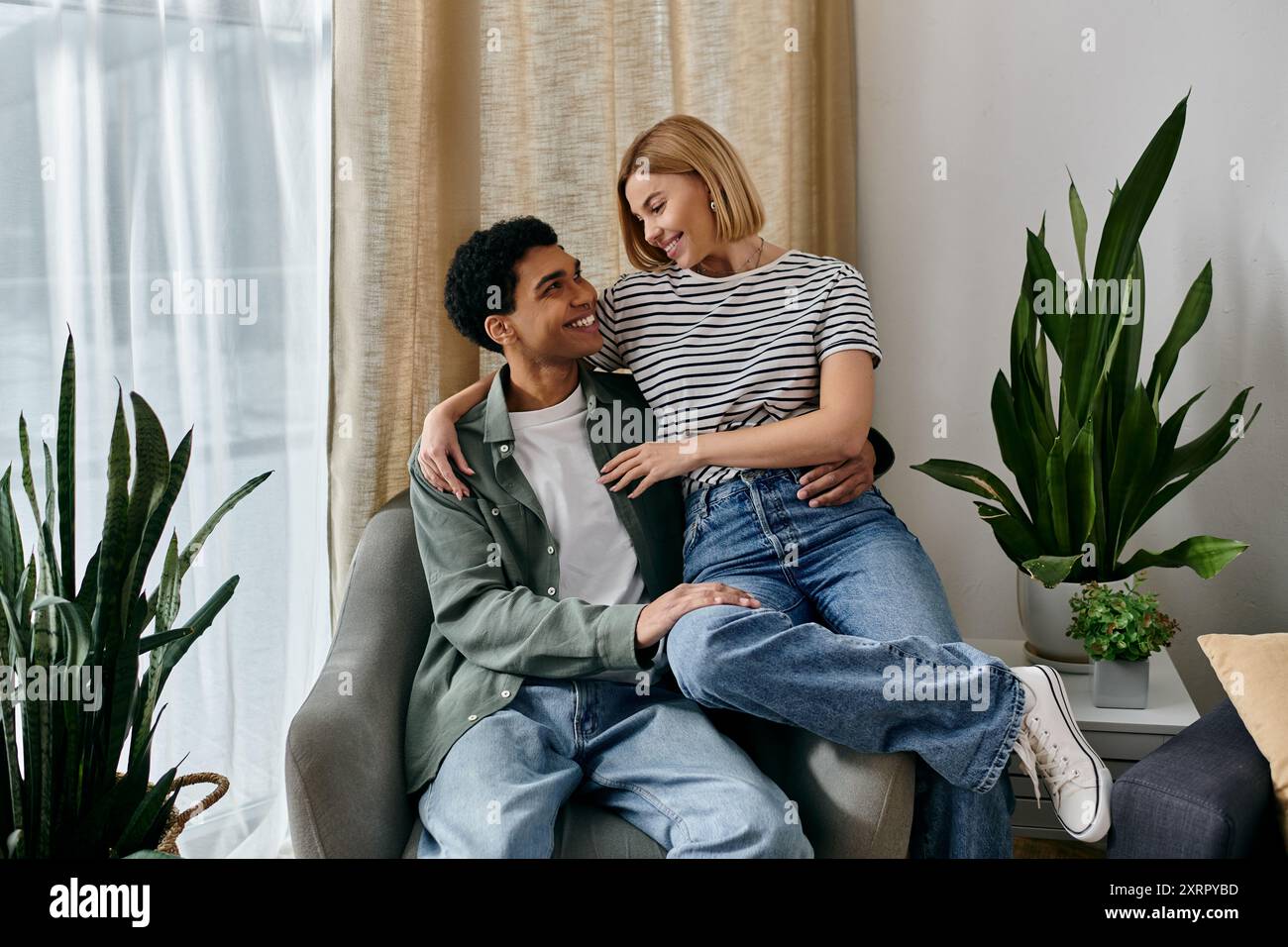 A young multicultural couple shares a loving moment in their modern ...