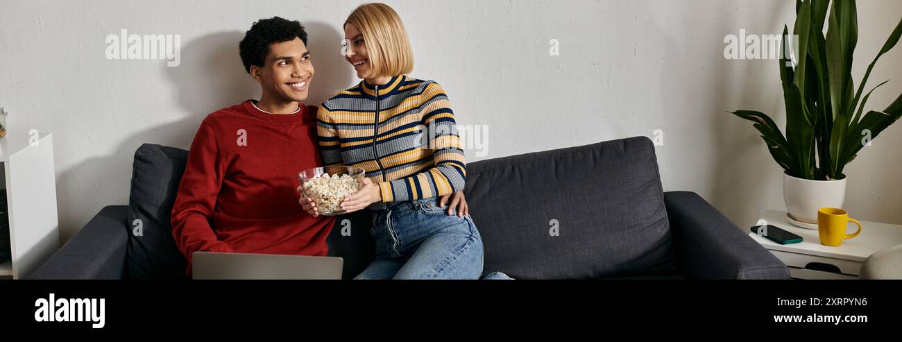 A happy multicultural couple relaxes on a couch in their apartment ...