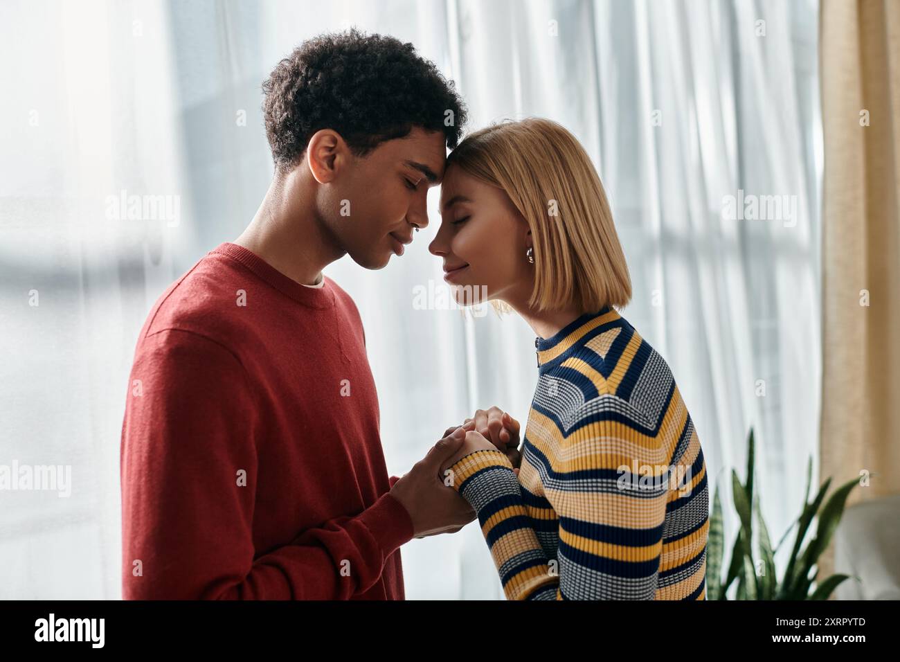 Happy multicultural couple stands hi-res stock photography and images ...