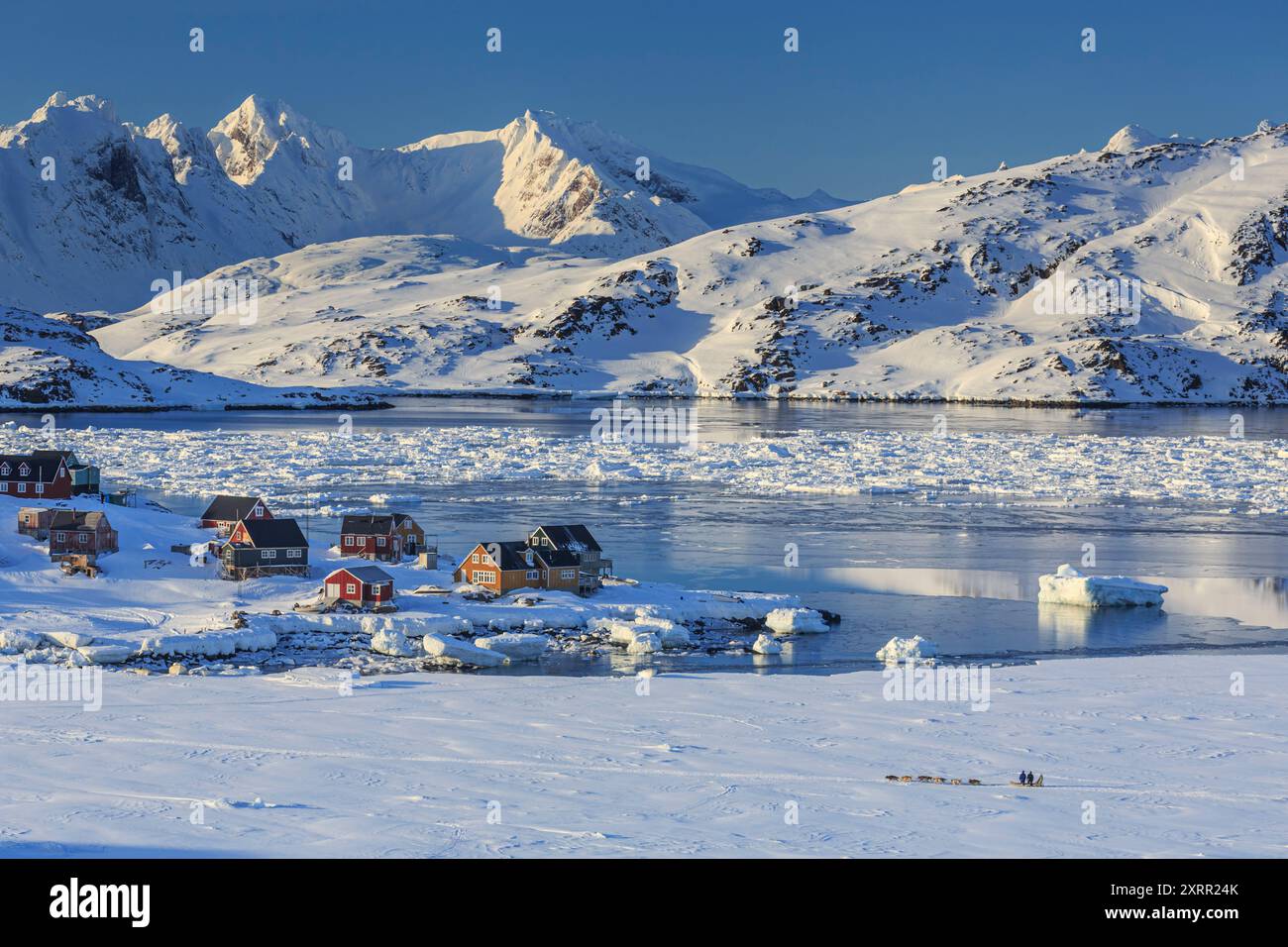 Scenic inuit settlement in a remote fjord with icebergs and mountains ...