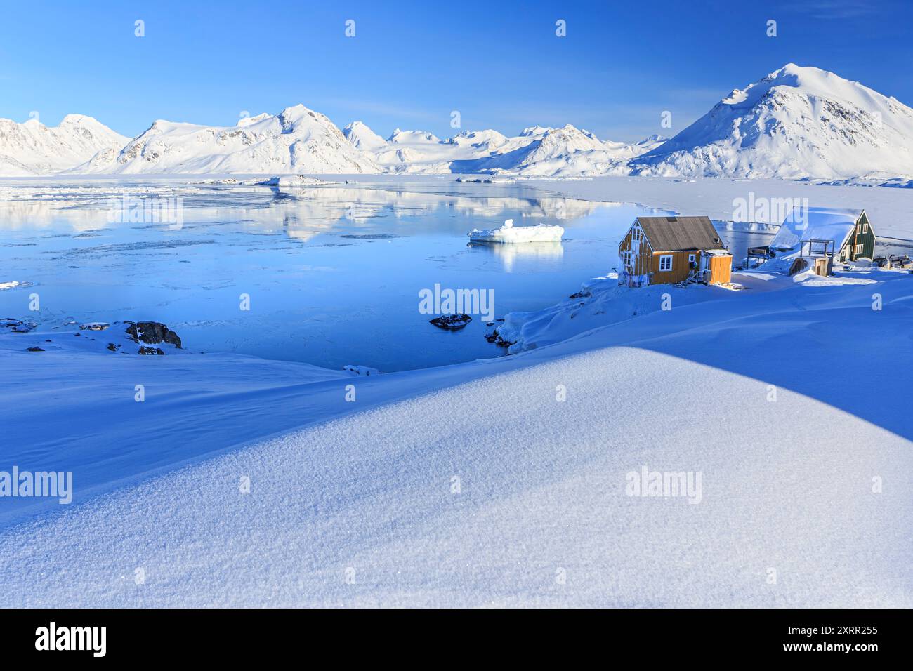 Scenic inuit settlement in a remote fjord with icebergs and mountains ...