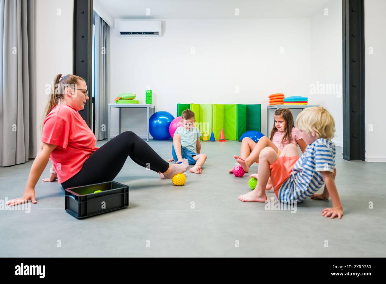 Children and female physical therapist during physical therapy session ...