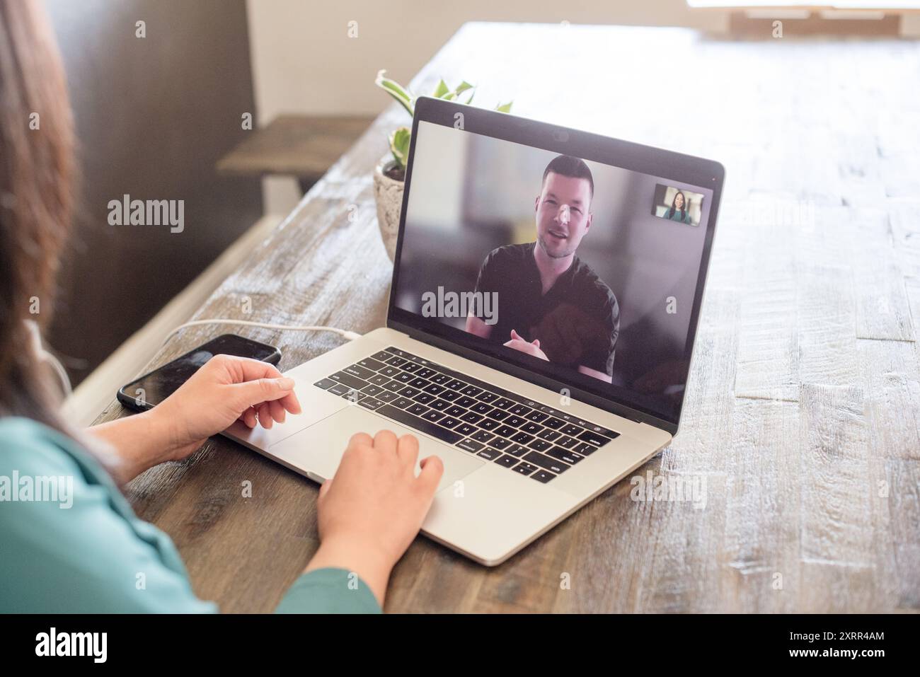 Woman on laptop looking at man on zoom Stock Photo - Alamy