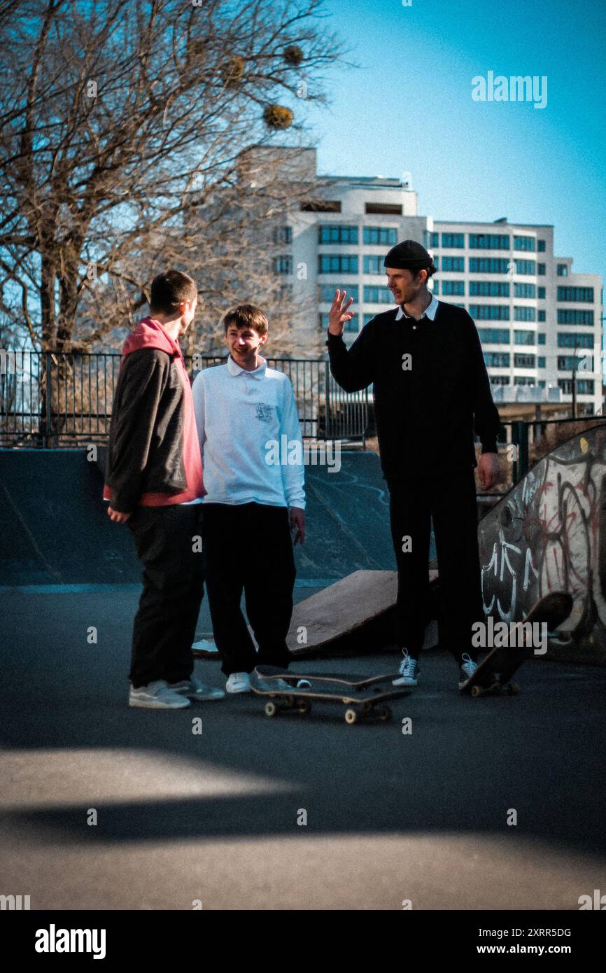 Three young skateboarders at a skate park in a city Stock Photo - Alamy