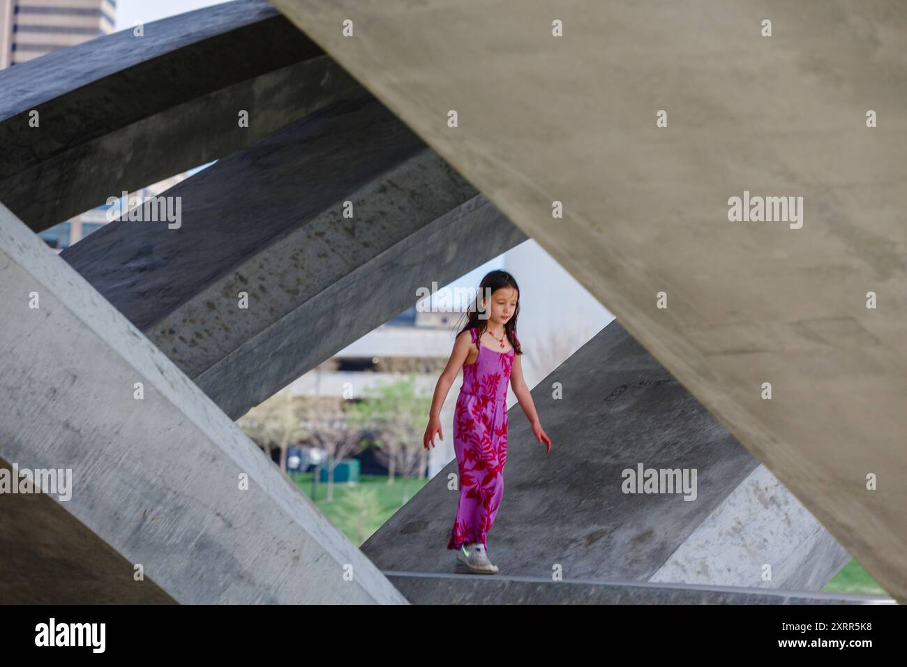 Little girl walking on cement arches supporting city bridge Stock Photo ...