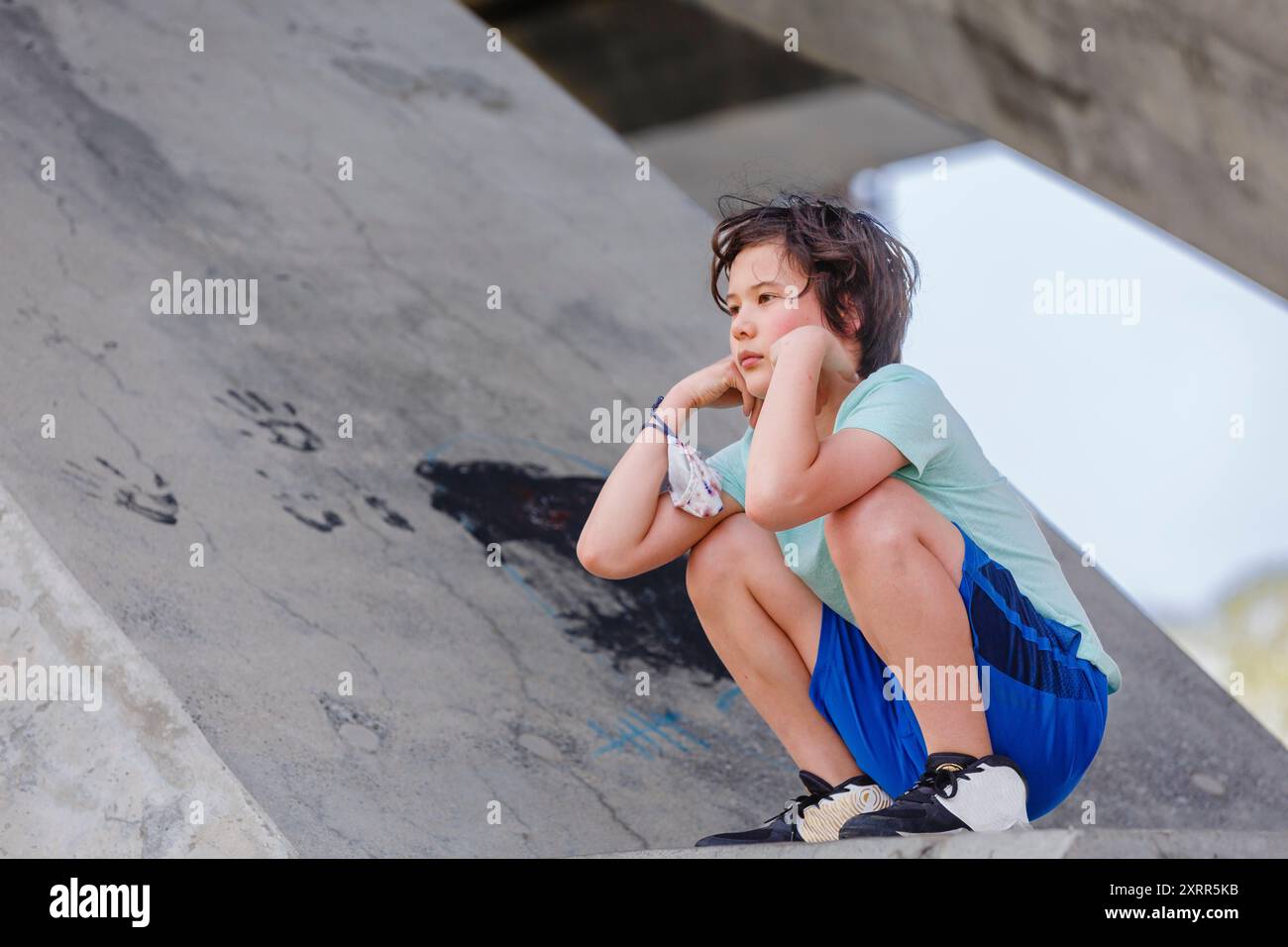 Sad boy sitting on stone hi-res stock photography and images - Alamy