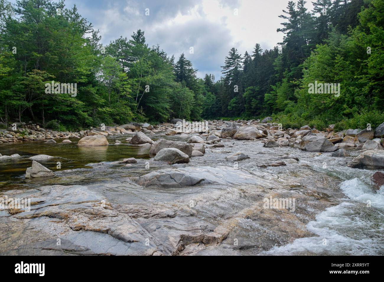 River flowing over rocks and boulders with trees Stock Photo - Alamy