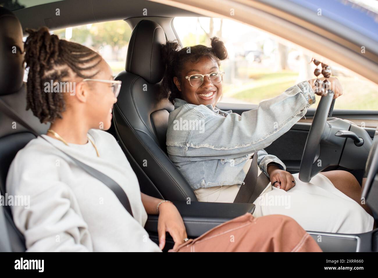 African American friends laughing together while driving Stock Photo ...