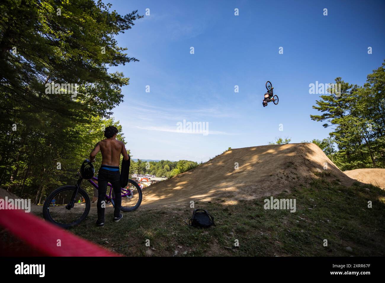 Slopestyle rider performing a back flip at a mountain bike park Stock ...