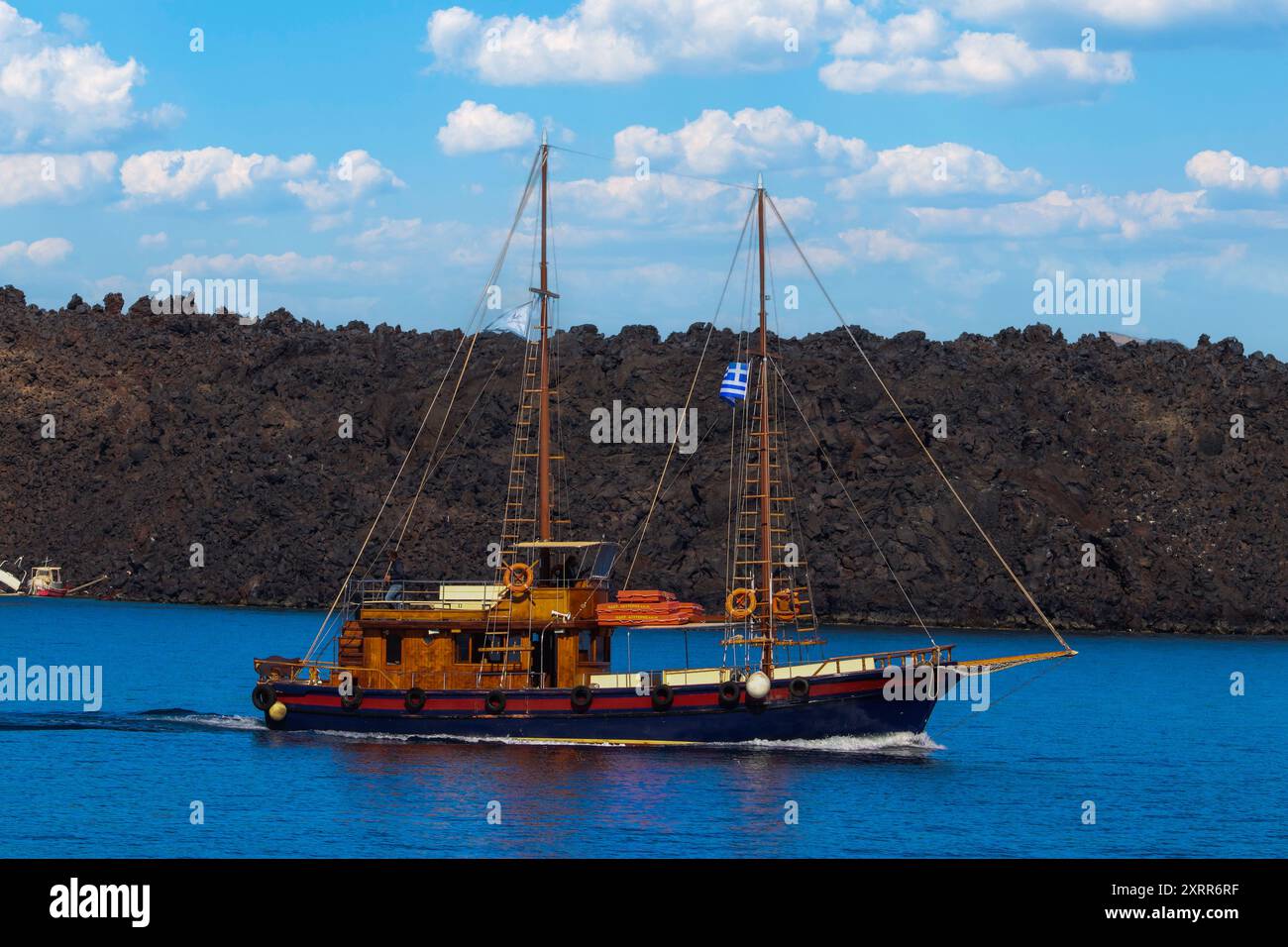 Sail Boat in Ocean in front of Rock Formation Stock Photo - Alamy
