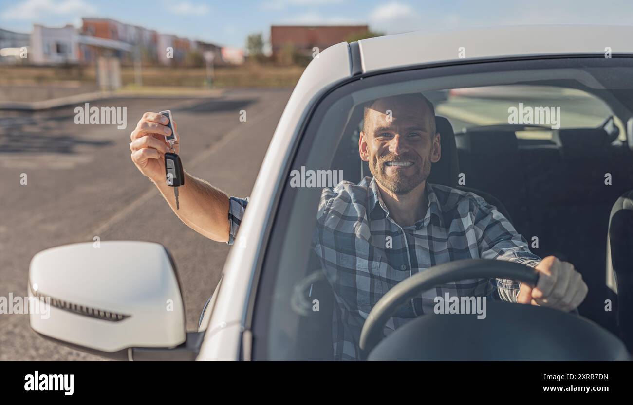 Attractive man holding keys against white car background Stock Photo ...