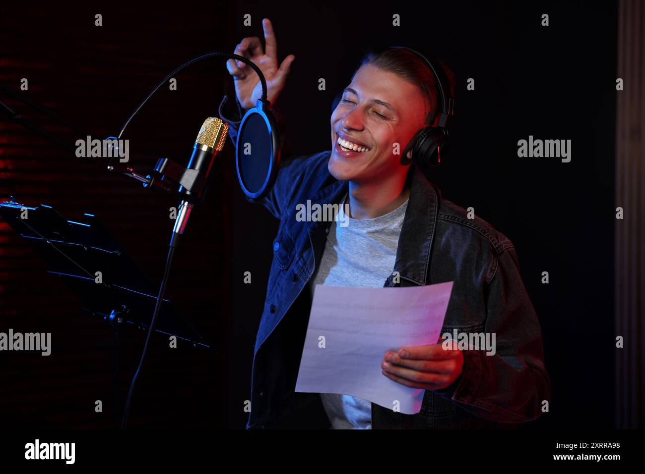Singer with sheet recording song in professional studio Stock Photo - Alamy