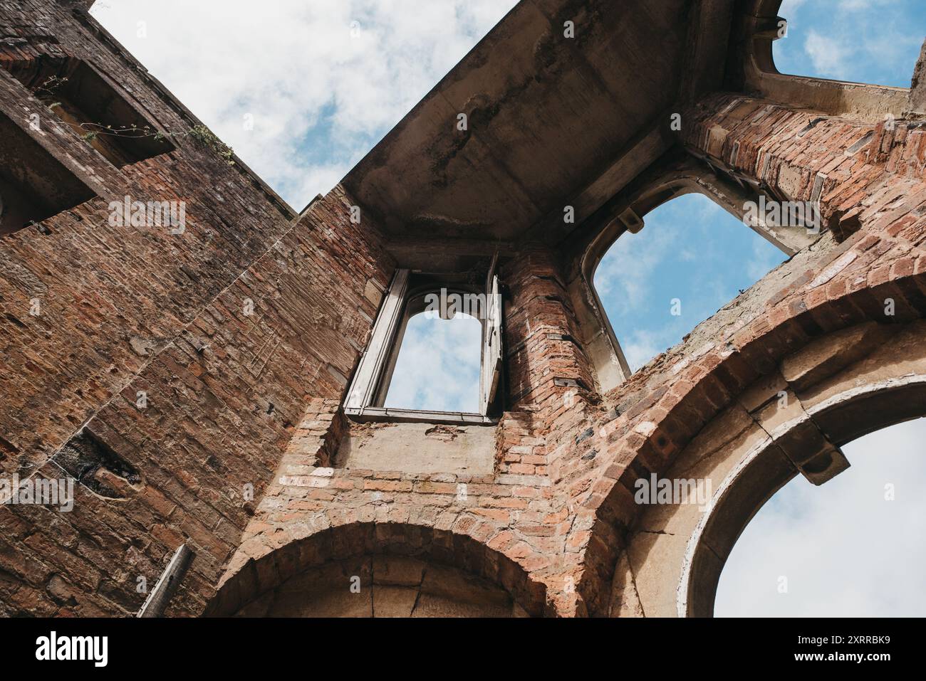 Historical Building in ruin with blue sky and white clouds. Cream brick ...