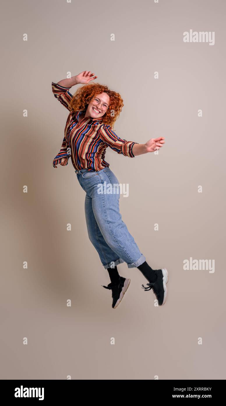 Beautiful funky woman jumping ecstatically in air and celebrating ...
