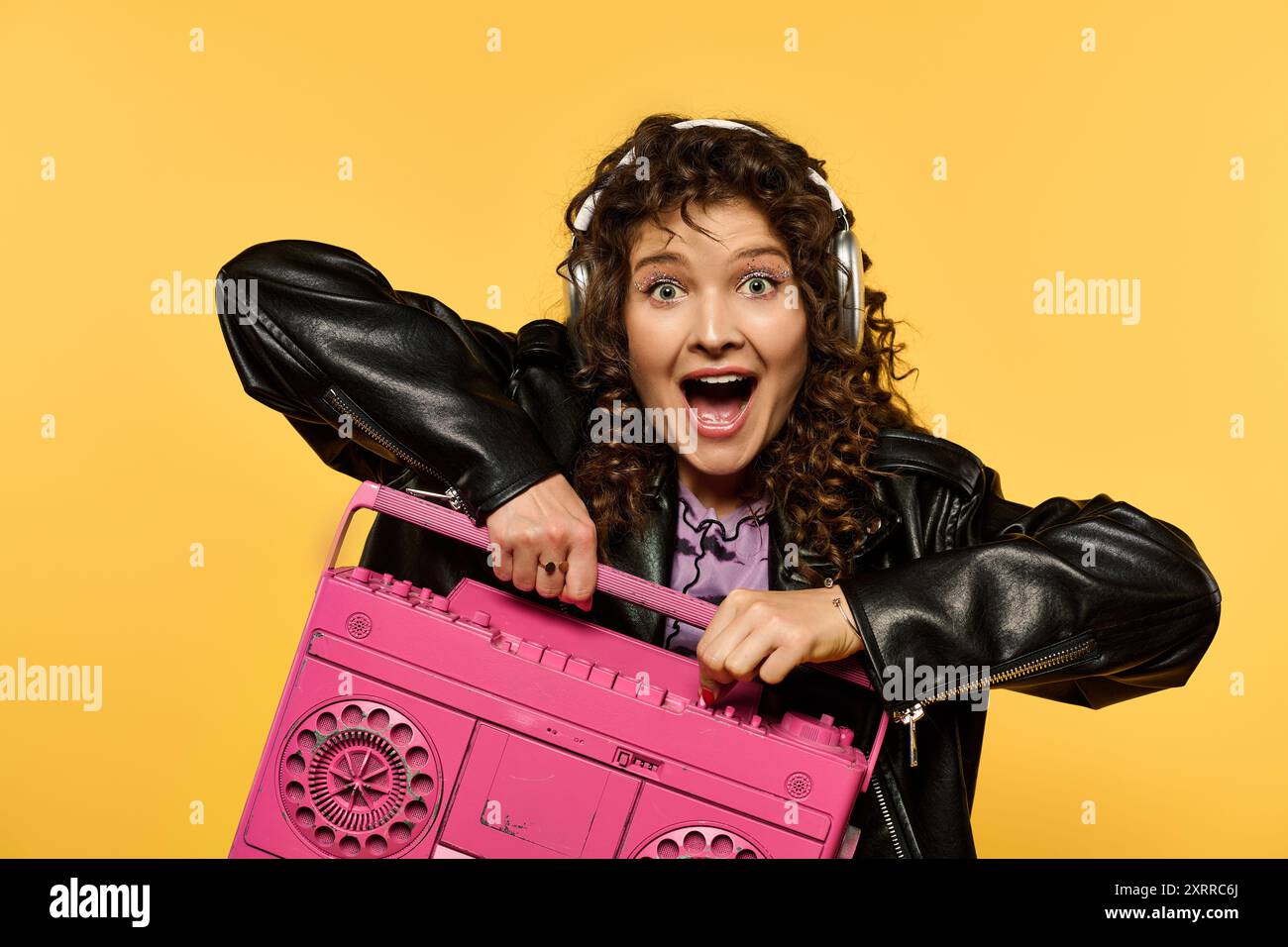 A young woman with curly hair is wearing a black leather jacket and ...