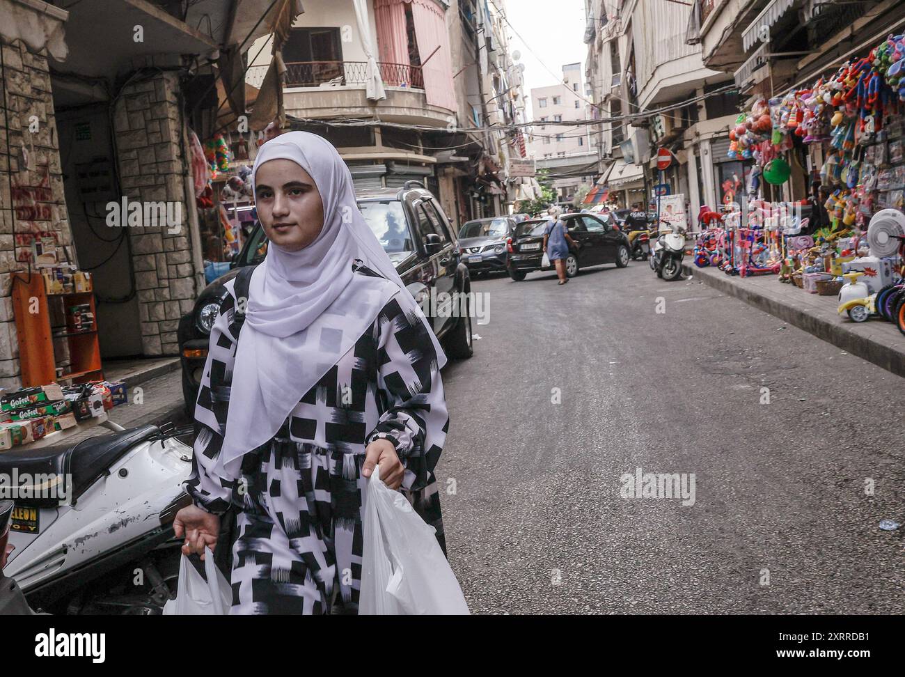 A young Muslim woman walks at a neighborhood in Beirut with plastic ...