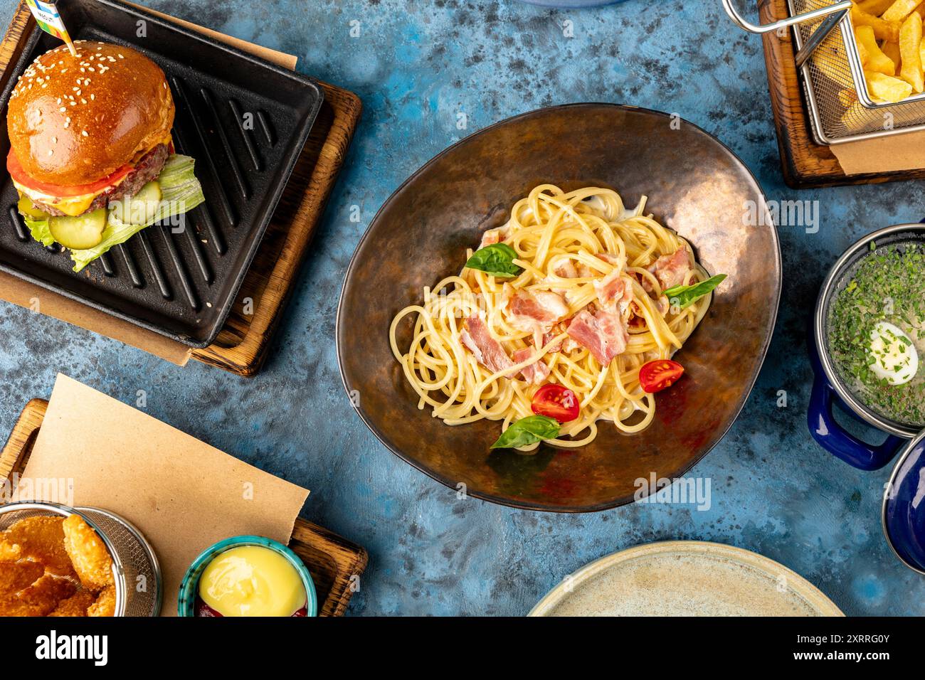 Top view of spaghetti with bacon, booger, french fries and broth. Set ...