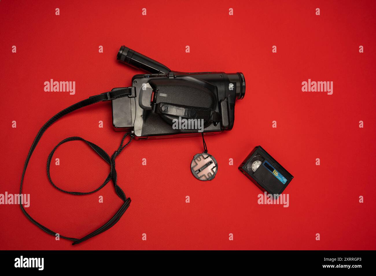 Vintage analog VHS video camera and a cassette with film on a red ...