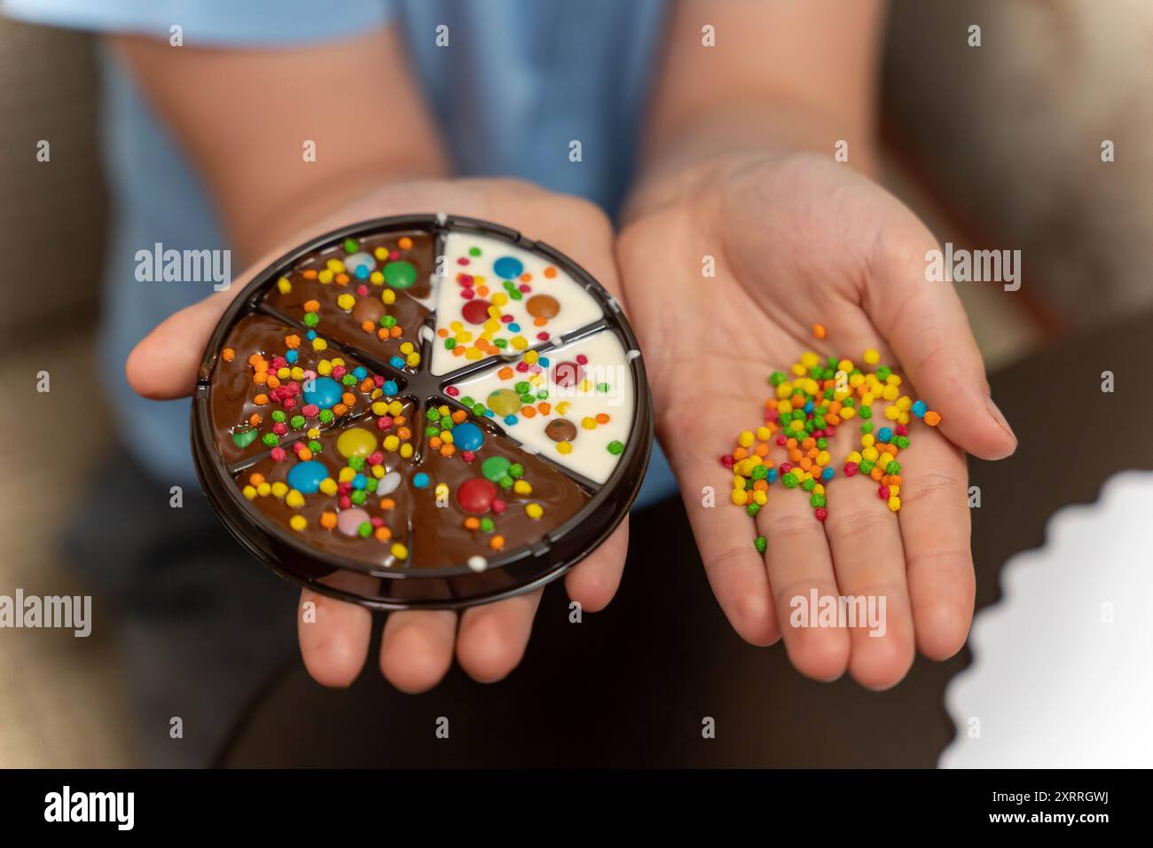 Individual holding homemade chocolate cake with colorful sprinkles ...