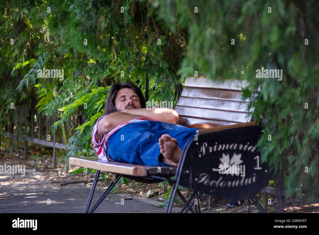 Bucharest, Romania - August 07, 2021: Homeless man sleeping on a bench ...