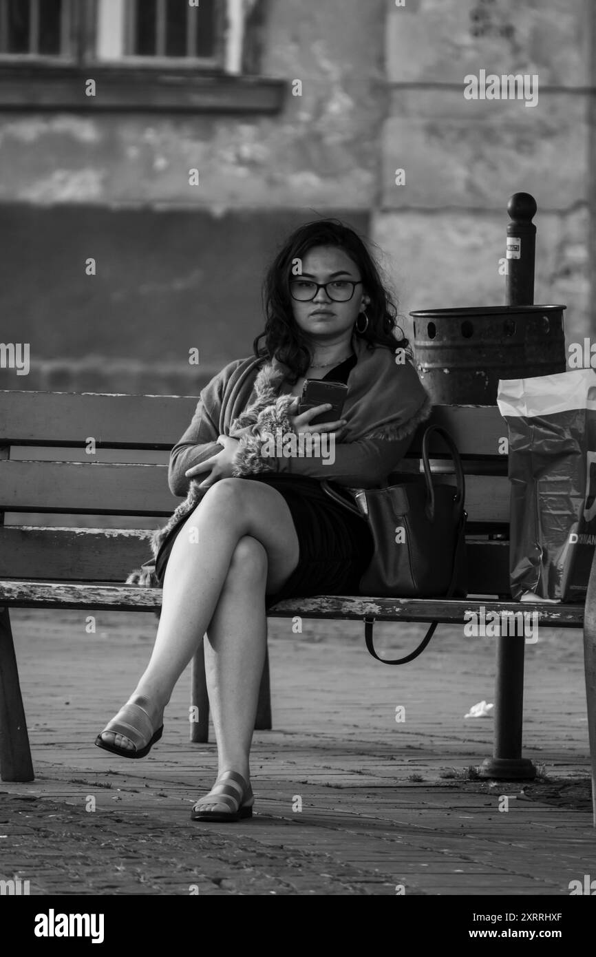 Timisoara, Romania - May 11, 2024: Woman sitting on a bench in the ...