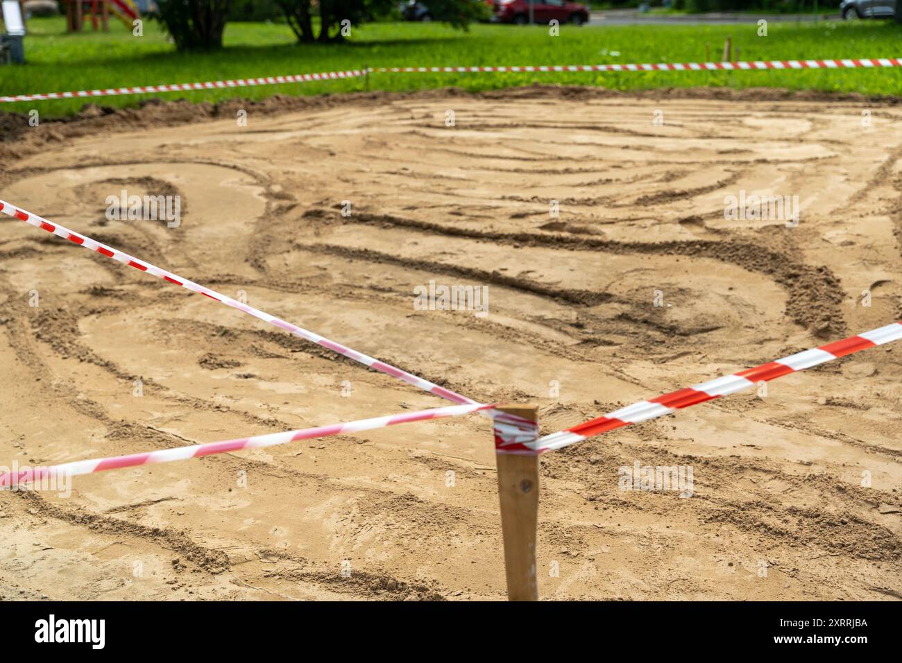 Caution tape marks off a sandy area with tire tracks Stock Photo - Alamy