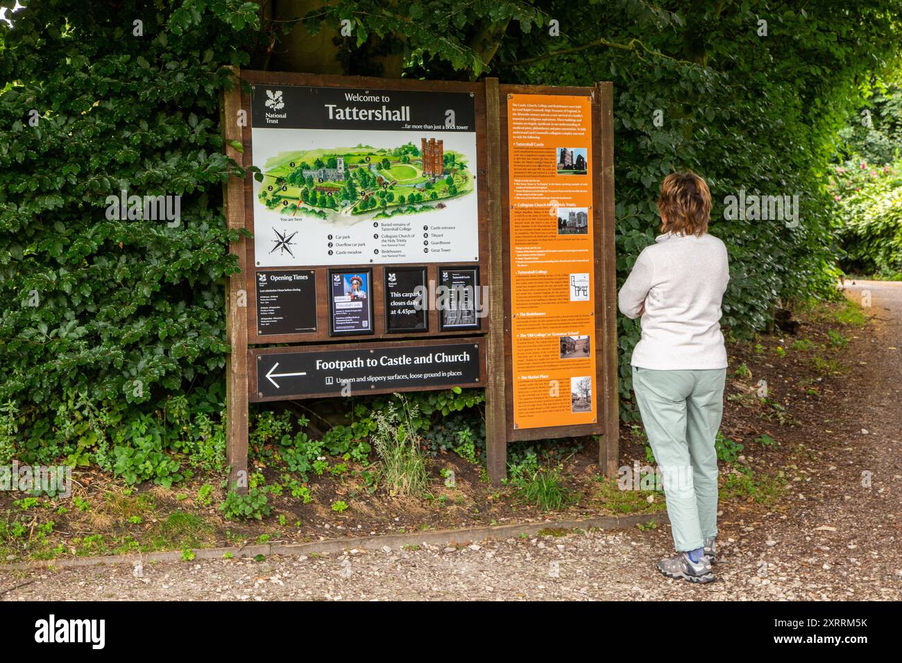 Woman reading notice board at Tattershall castle and church visitors ...