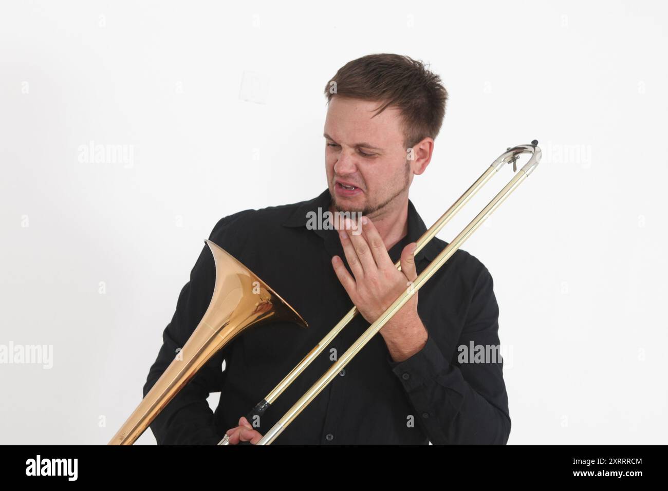 handsome young man with trombone on white background Stock Photo - Alamy