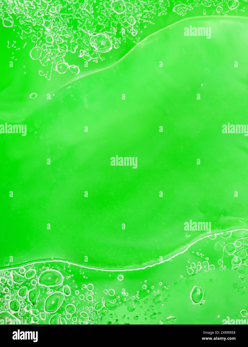 Abstract close-up of bright green liquid with floating bubbles ...