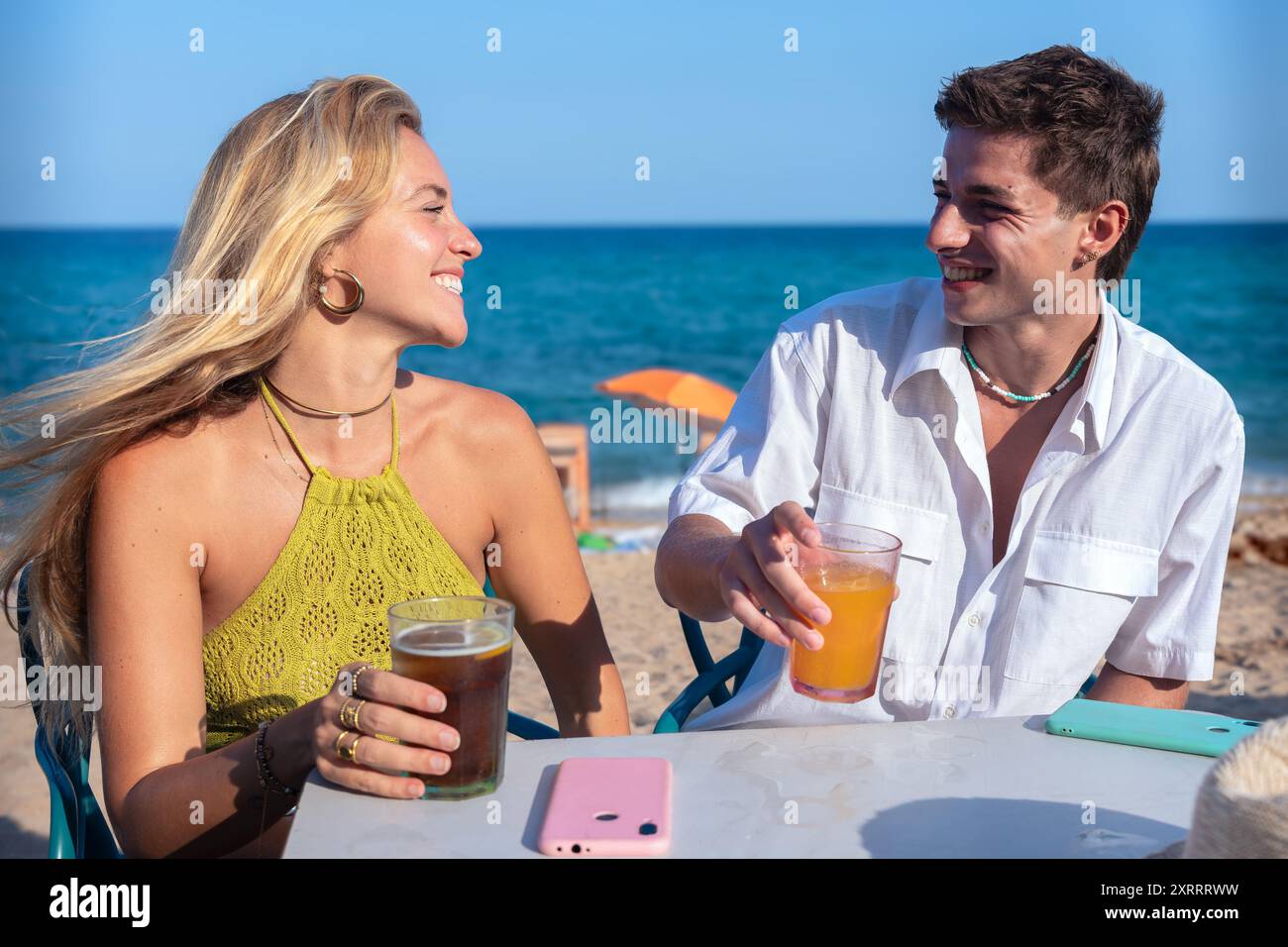 Happy young couple on vacation,drinking in restaurant Stock Photo - Alamy