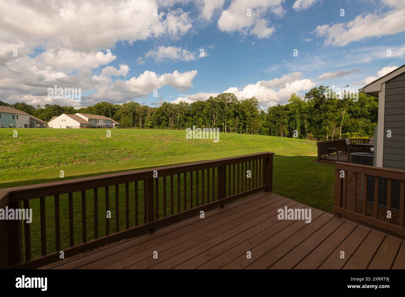 Wooden backyard deck view with woods and dramatic sky during summer ...
