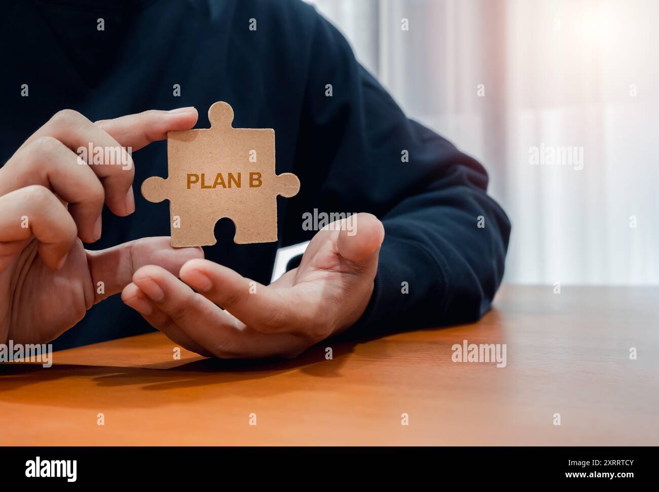Text "PLAN B"on jigsaw puzzle piece holding by businessman's hand, on ...