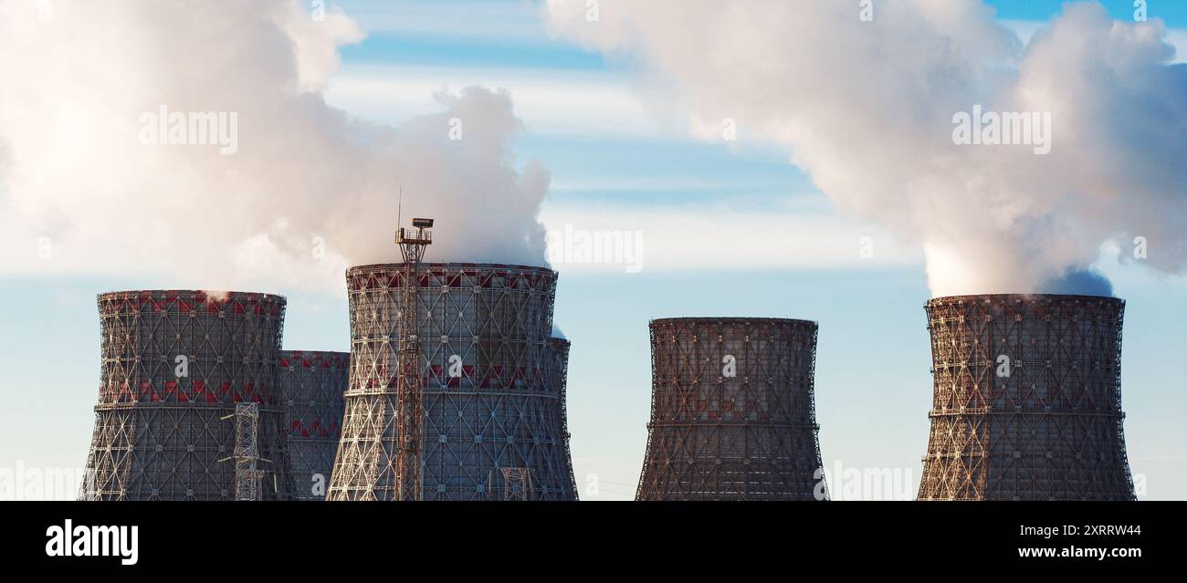 Panoramic view of industrial cooling towers emitting steam ...