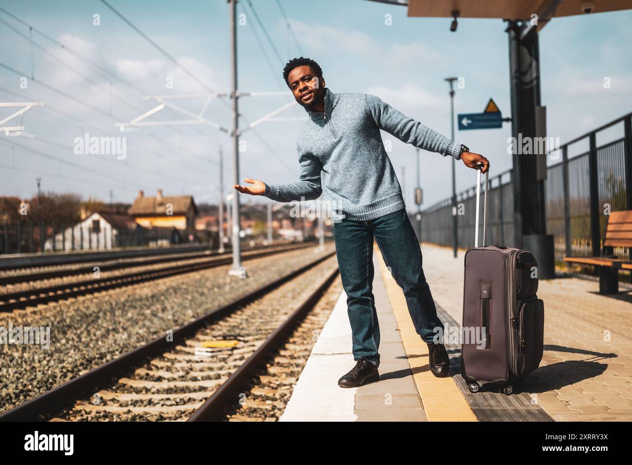 Angry man with a suitcase standing on a railway station Stock Photo - Alamy