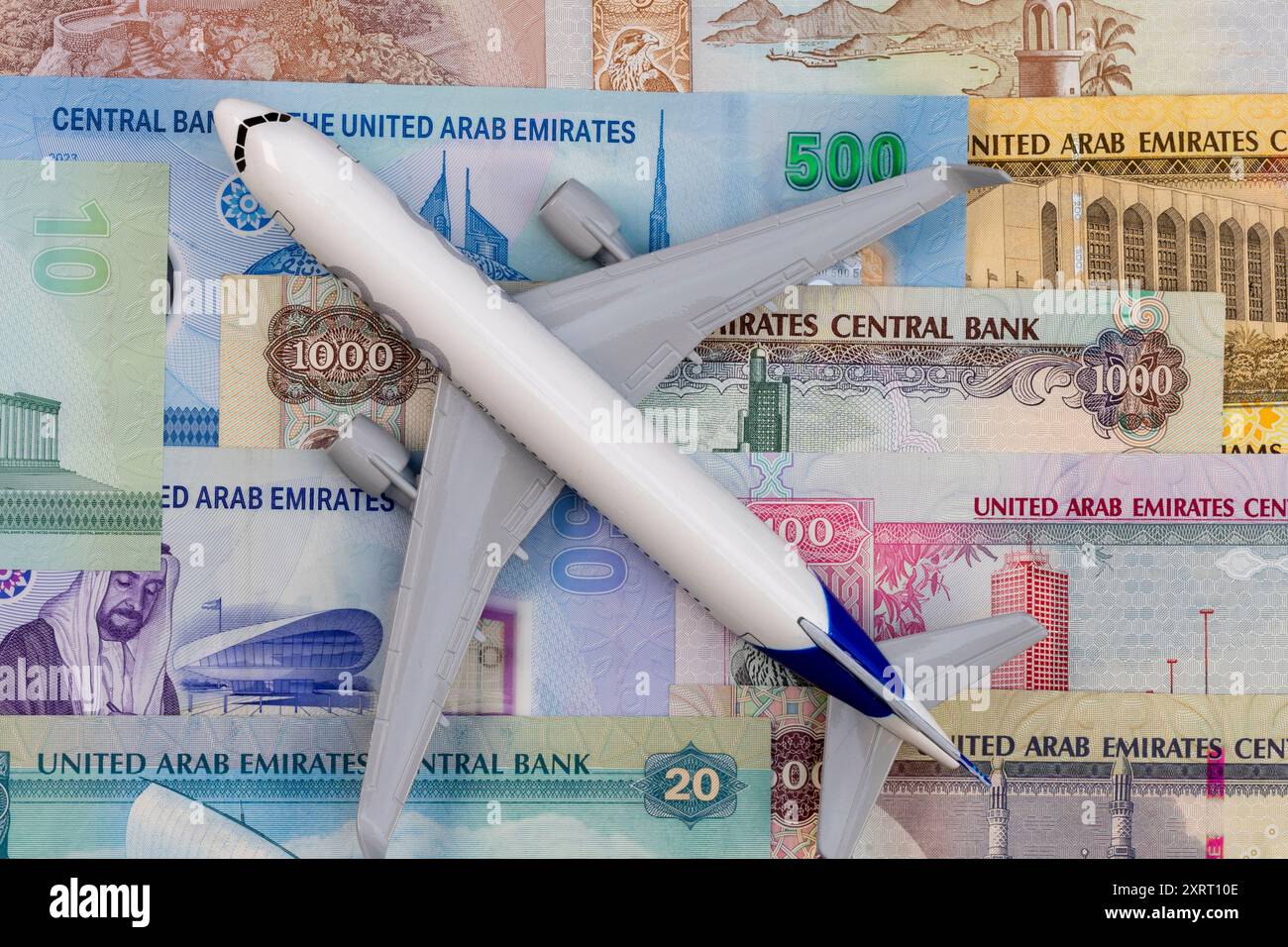 Toy model aeroplane on UAE currency notes. Travel expenses concept ...