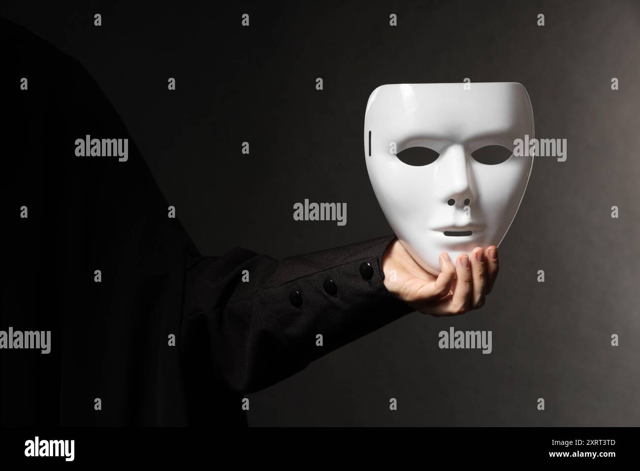 Theatrical performance. Man holding plastic mask on black background ...