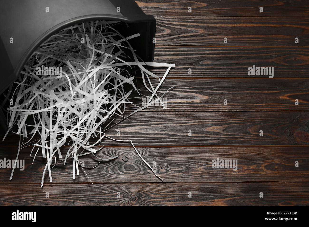 Shredded paper strips in bin on wooden table, space for text Stock ...