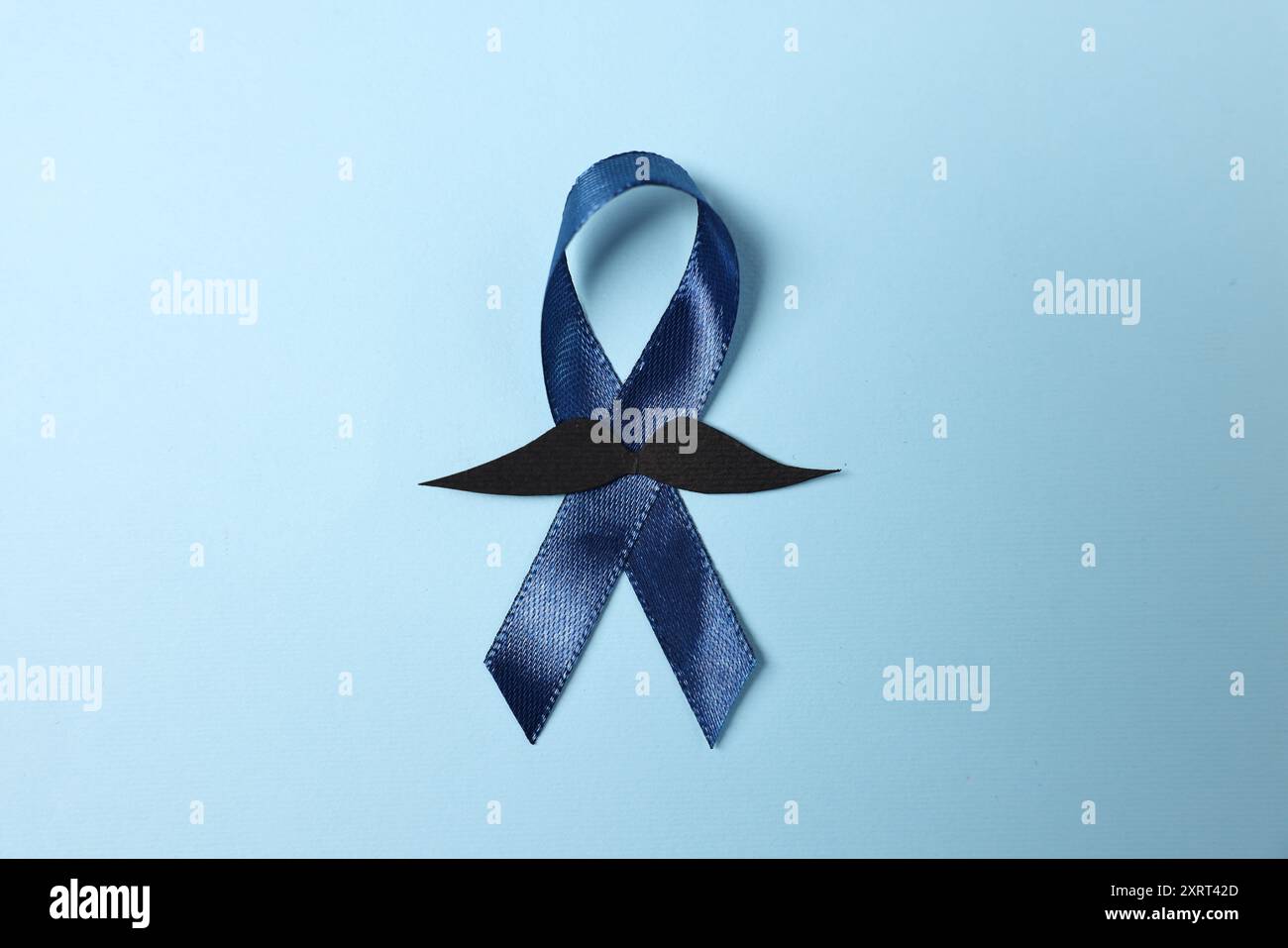 Dark blue ribbon and fake mustache on color background, top view ...