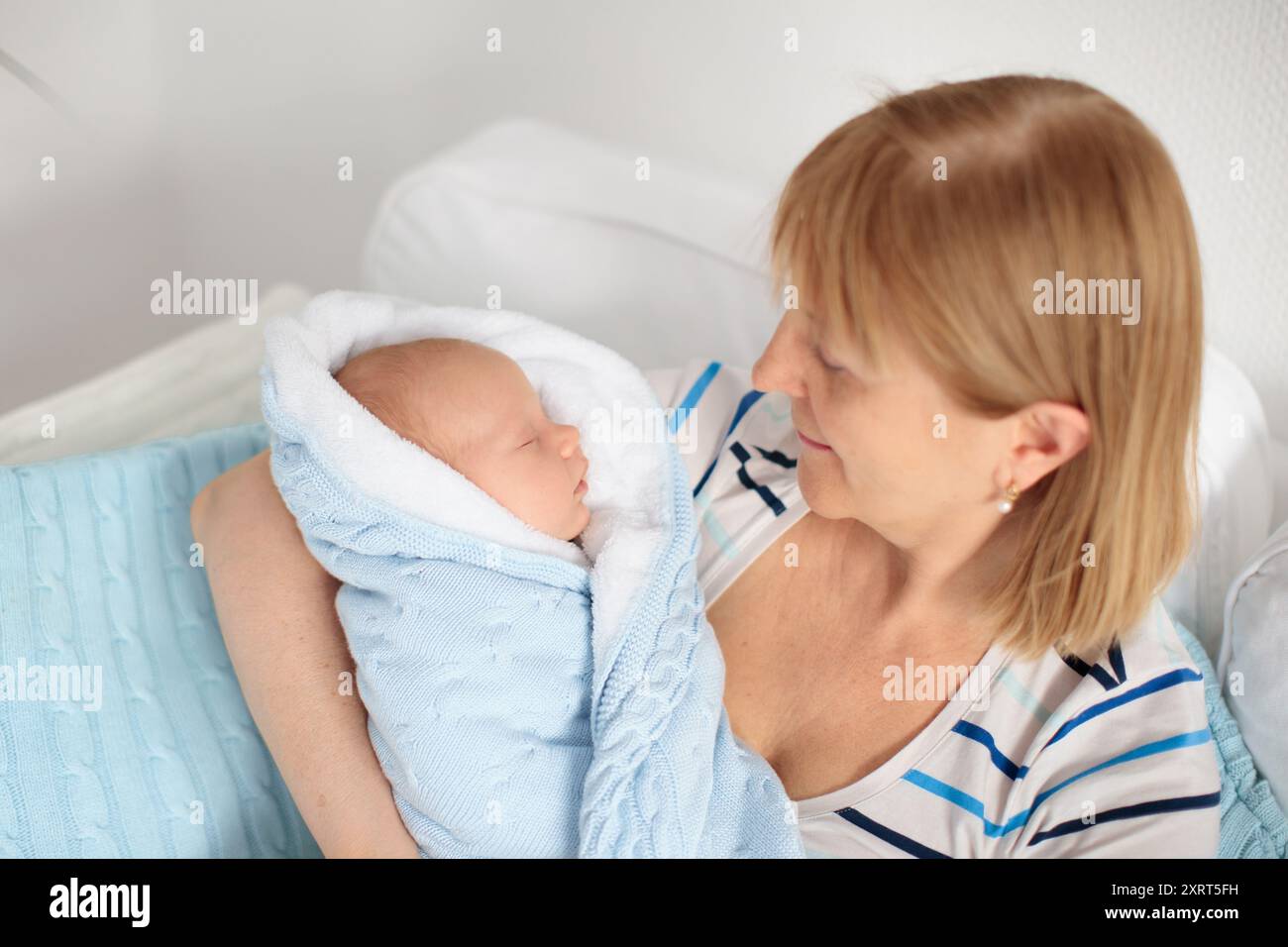 Grandmother holding newborn baby. Grandma meeting new family member ...