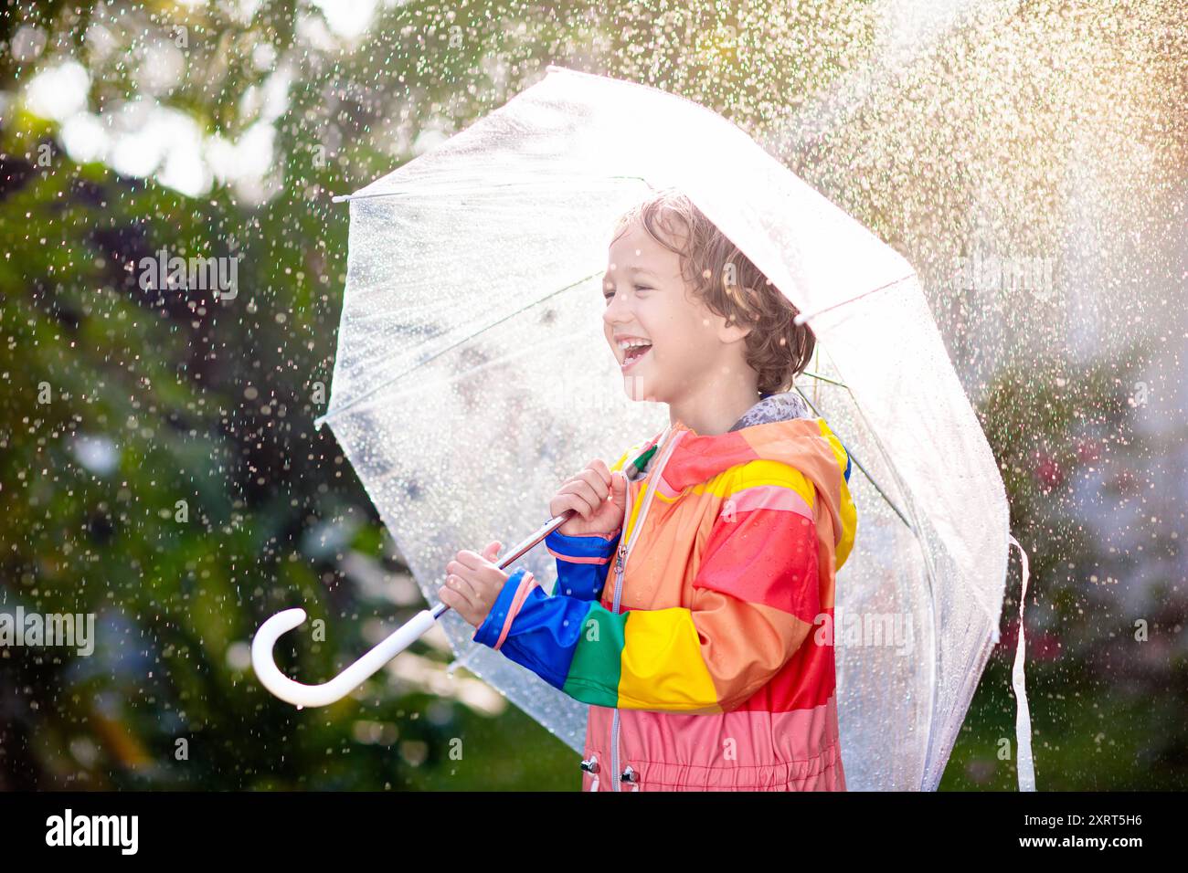 Child playing in autumn rain. Kid with umbrella. Little boy running in ...